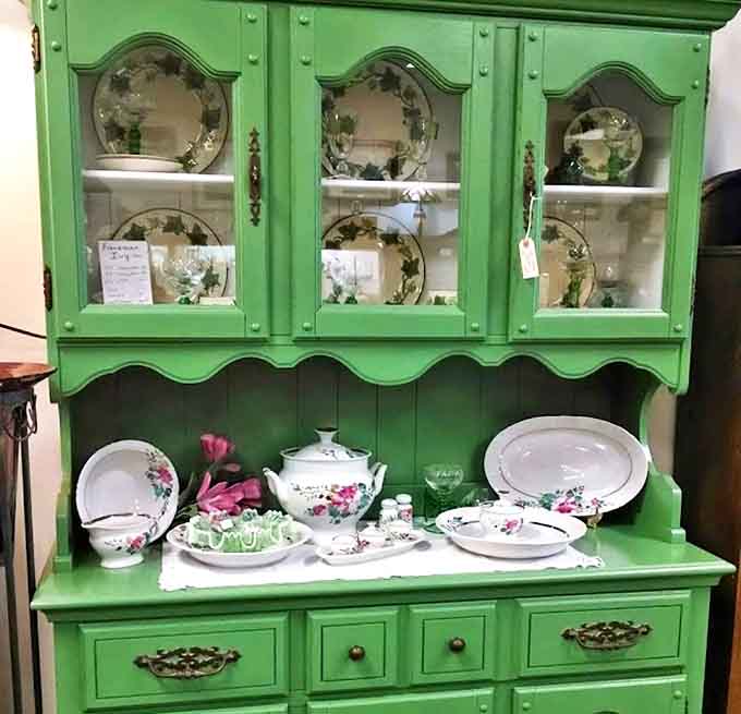 This mint-green hutch isn't just furniture—it's a stage where vintage china performs its delicate ballet of floral patterns and gold trim.