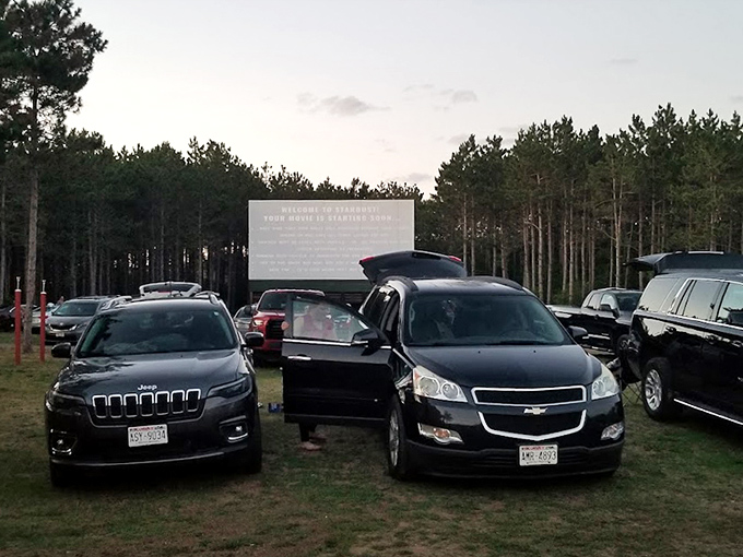 Moviegoers prepare their viewing spots, some opting for the comfort of their vehicles, others setting up outside.