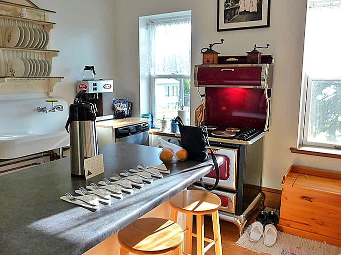 The vintage kitchen balances historical charm with modern necessities, where breakfast preparations begin before guests stir from their cozy beds.