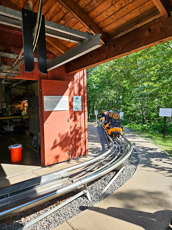 The coaster's loading zone buzzes with activity as staff ensure safety while maintaining the cheerful atmosphere of controlled chaos and anticipation.