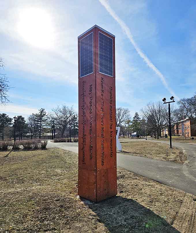 This peace pole stands as a quiet sentinel among more playful pieces, offering messages of harmony in multiple languages.