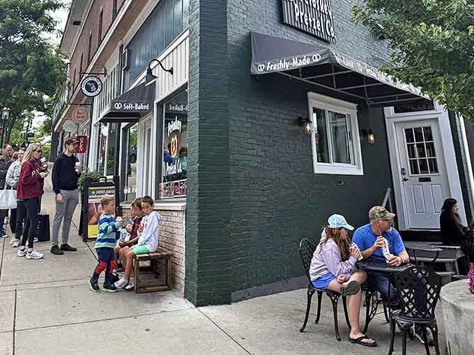 The sidewalk scene at Petoskey Pretzel Co. becomes a community gathering spot where strangers bond over shared love of twisted dough.