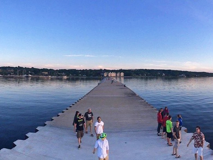 The pier stretches toward the horizon like nature's runway, inviting evening strollers to walk straight into a Michigan sunset.