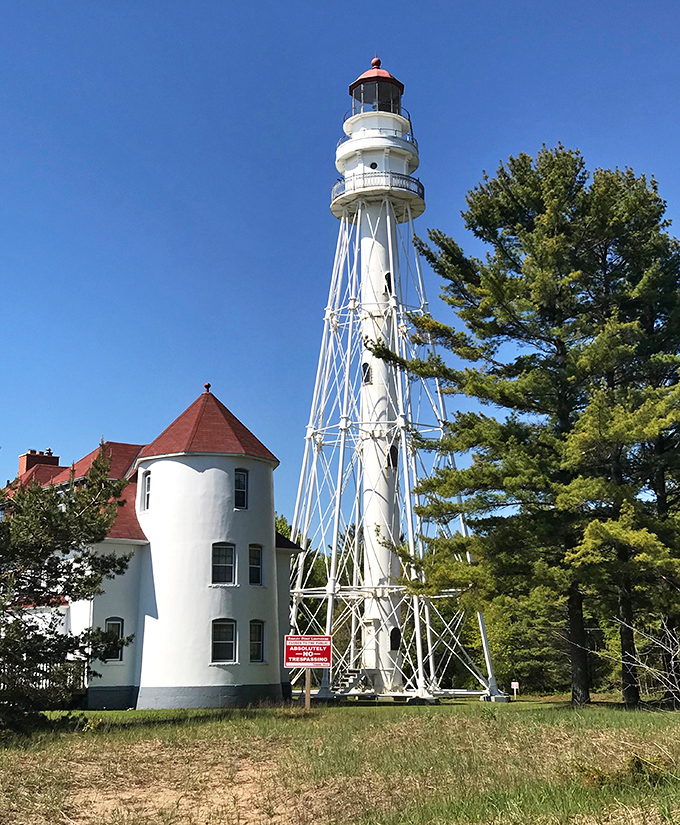 Rawley Point Lighthouse stands tall against the blue sky, having guided ships safely through Lake Michigan's waters since before Netflix existed.