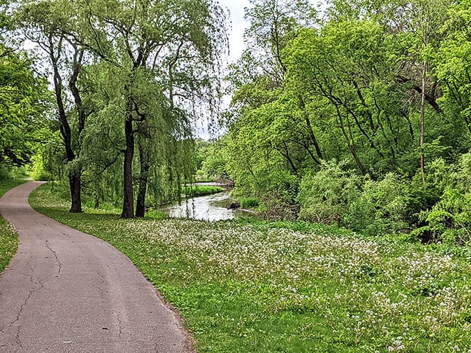 Spring explodes in a riot of green along this winding path, where weeping willows bow gracefully toward their reflections.
