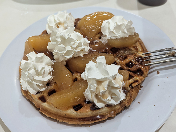 Waffle architecture at its finest &ndash; crisp exterior, fluffy interior, topped with caramelized apples and dollops of fresh whipped cream.