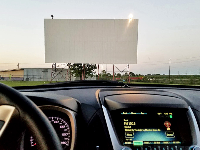 The big screen dominates the landscape, drawing all eyes upward as stories unfold against the backdrop of an Illinois evening sky.