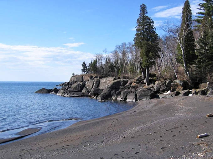 Lake Superior's volcanic history created this rare black sand beach, where footprints tell stories that wash away with each wave.