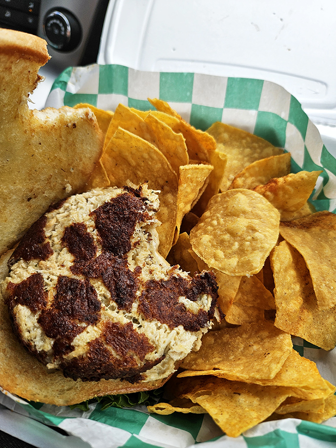 A perfectly grilled burger patty nestled on a fresh bun with all the fixings &ndash; simple pleasures executed with culinary precision.