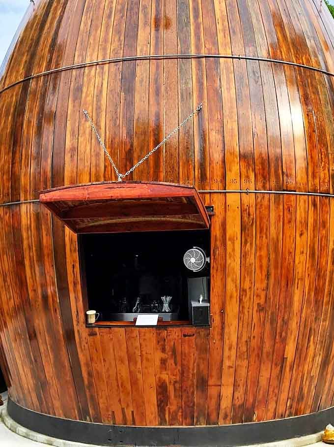 The barrel's service window, framed by rich wooden planks, offers a portal to simpler times when roadside stands were summer's main attraction.