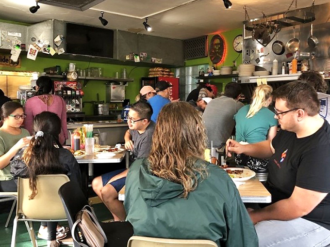 The controlled chaos of a busy morning – where strangers become temporary breakfast companions in this cozy culinary clubhouse.