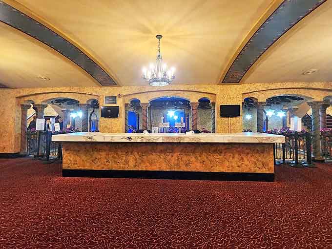 The grand lobby bar serves as both functional gathering space and architectural showpiece, where patrons mingle beneath ornate ceiling details.