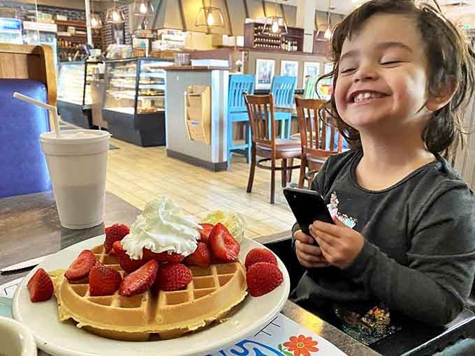 A young diner discovers the joy of Keys' famous waffles, topped with fresh strawberries and a cloud of whipped cream.