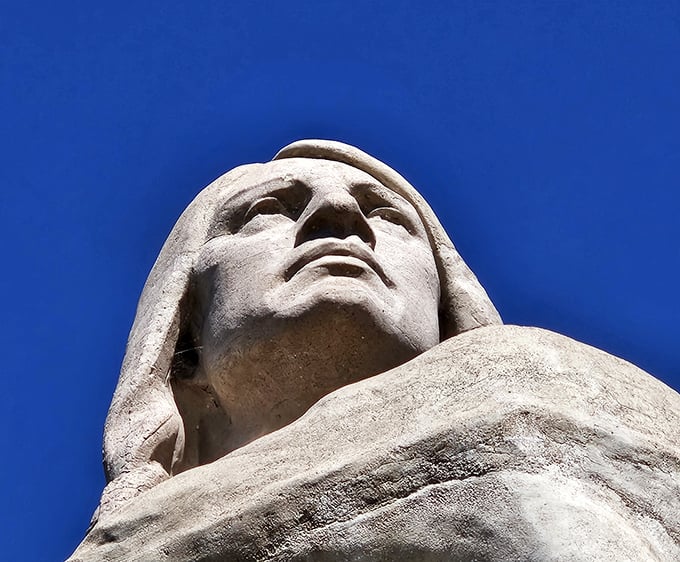 Looking up at the statue's face creates a dramatic perspective that emphasizes its monumental scale and stoic expression.
