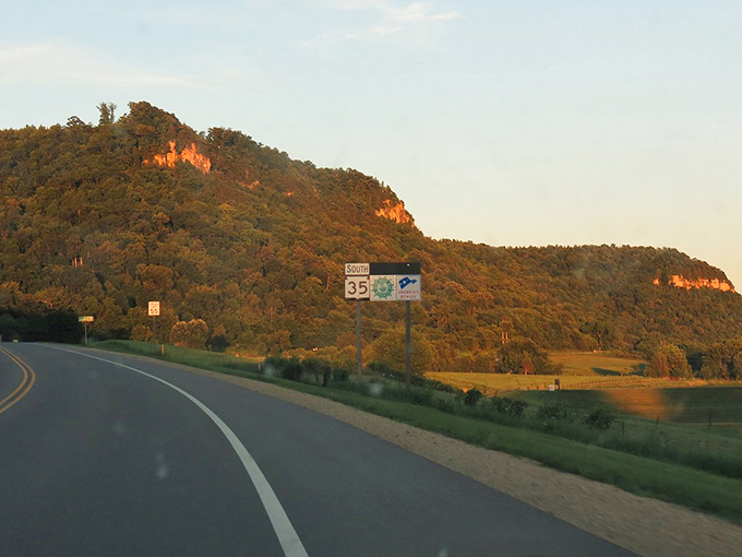 Golden hour transforms ordinary roadways into pathways of possibility, with bluffs catching the sun's final wink before twilight.