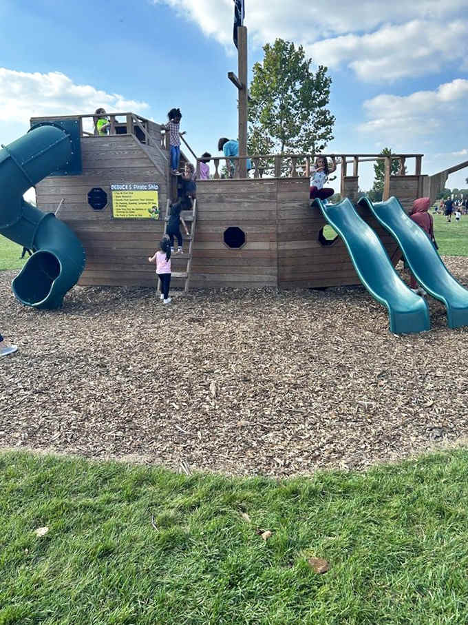 Children scramble aboard a wooden ship playground complete with slides, offering a nautical adventure in the middle of farm country.