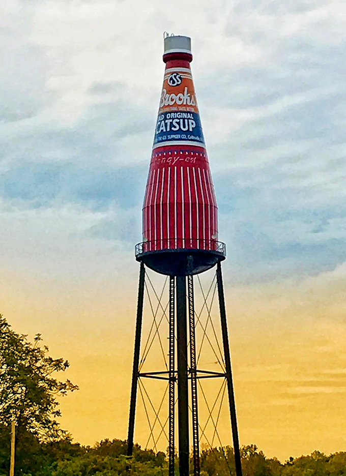 Golden hour transforms the Brooks Catsup Bottle into a glowing beacon of roadside charm against the sunset sky.
