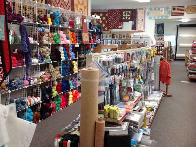 Colorful threads line the walls like an artist's palette, proving that sometimes the supporting characters are as important as the star fabric.