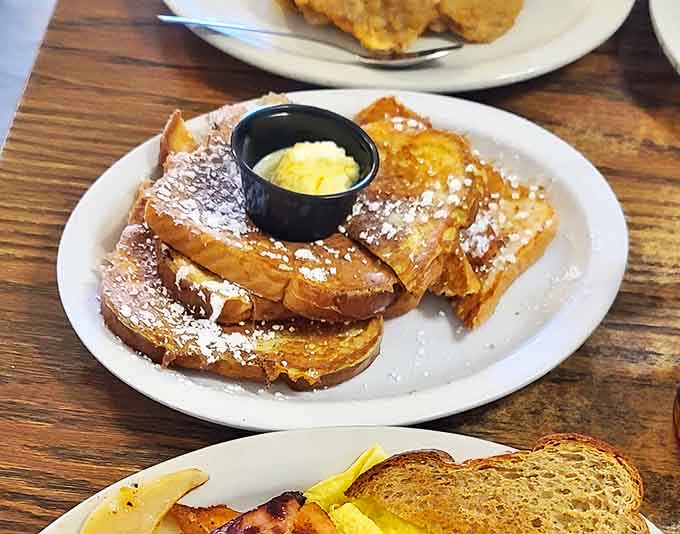 French toast transformed into a breakfast dessert &ndash; thick slices grilled golden, dusted with powdered sugar, waiting for that first glorious maple syrup pour.