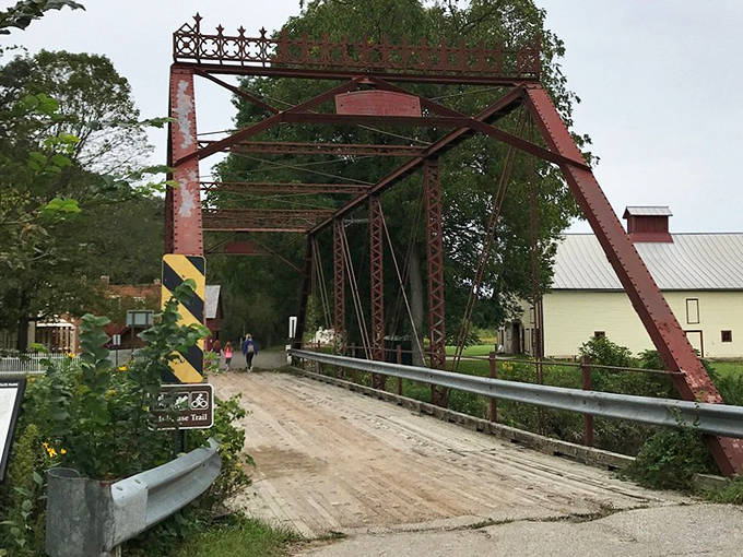 The rusty truss bridge spans time as well as water, connecting modern visitors to generations who crossed before smartphones existed.