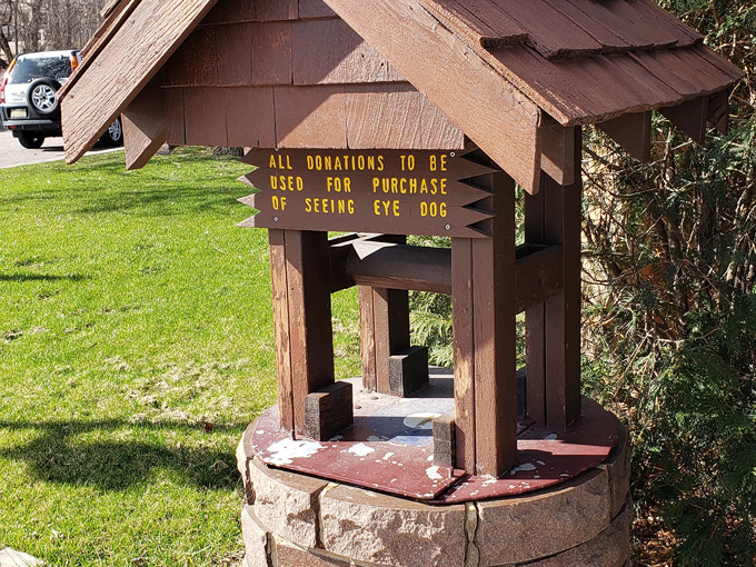 A charming wishing well invites visitors to donate, with funds supporting guide dog programs through the local Lions Club.