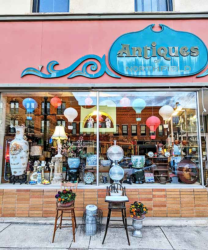 The iconic turquoise sign of Antiques of Northfield beckons passersby with promises of treasures within, a colorful beacon against the salmon-colored storefront.