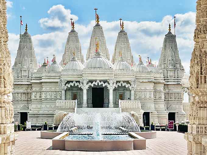 The magnificent BAPS Shri Swaminarayan Mandir rises from suburban Chicago like a marble mirage, its five spires reaching skyward with breathtaking elegance.