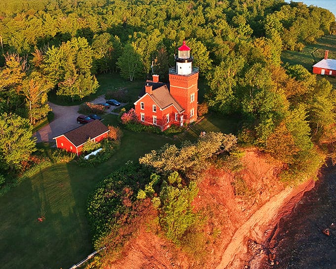 Majestic and proud, the Big Bay Point Lighthouse stands sentinel over Lake Superior, its brick facade glowing warmly in the golden afternoon light.