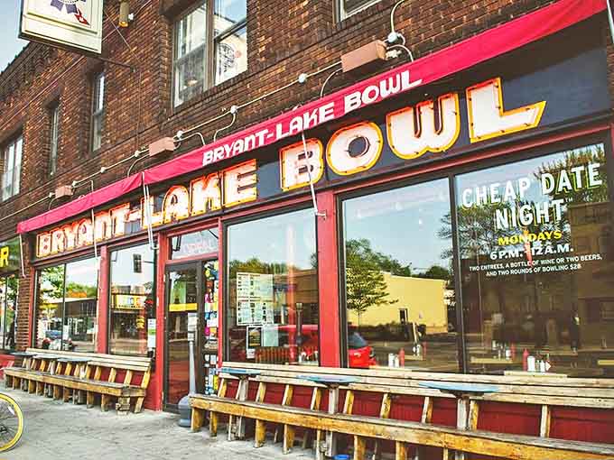 The iconic red storefront of Bryant-Lake Bowl beckons passersby with its vintage neon glow, promising good times inside.