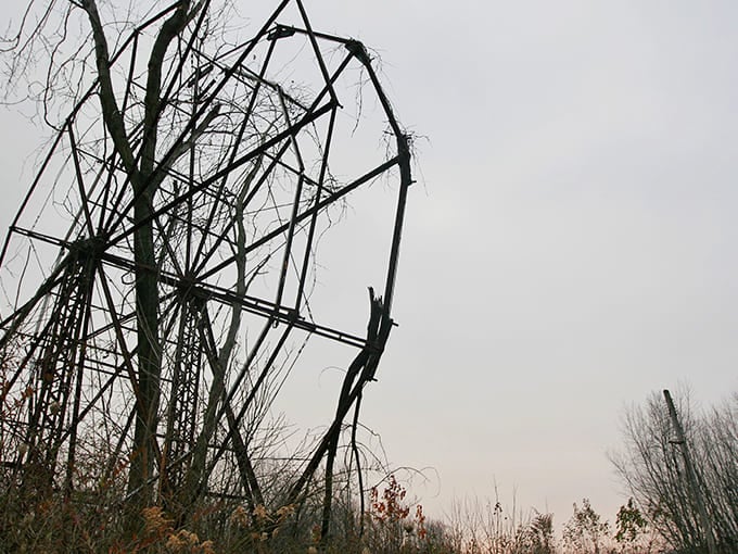 The ghostly silhouette of Chippewa Lake Park stands sentinel against an overcast sky, nature slowly reclaiming what humans abandoned decades ago.