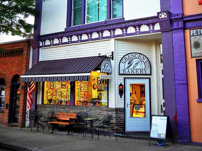 The charming storefront of Crescent Bakery beckons with its classic white facade and purple accents, promising sweet treasures within this Frankfort landmark.