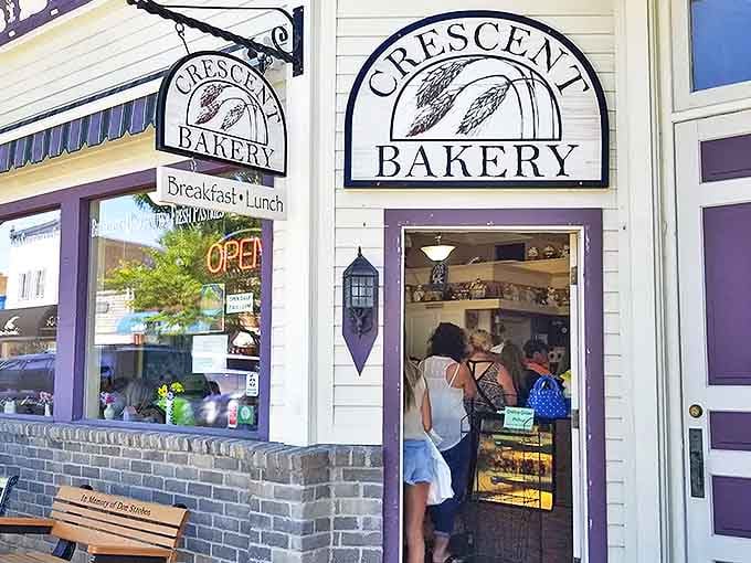 That purple trim against white siding isn't just charming, it's like the bakery is winking at you from across the street, promising delicious things inside.