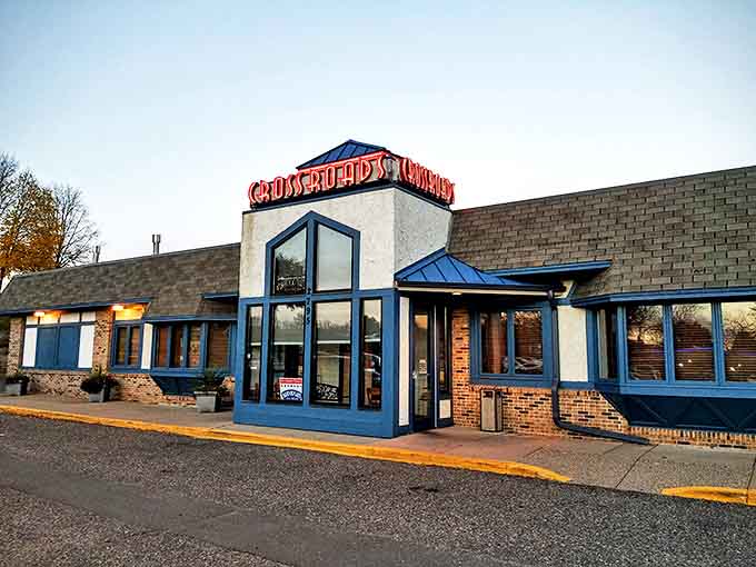 The welcoming blue-trimmed exterior of Crossroads Delicatessen stands like a culinary lighthouse in Minnetonka, promising comfort food treasures within.