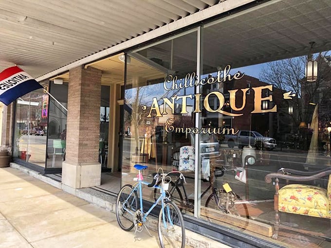 The welcoming storefront of Chillicothe Antique Emporium beckons with golden lettering and a vintage blue bicycle, promising treasures within.