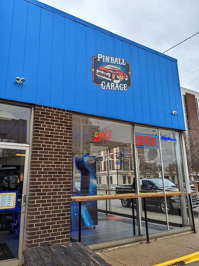 The vibrant blue exterior of Pinball Garage stands out on Hamilton's Main Street, promising retro thrills behind its inviting facade.