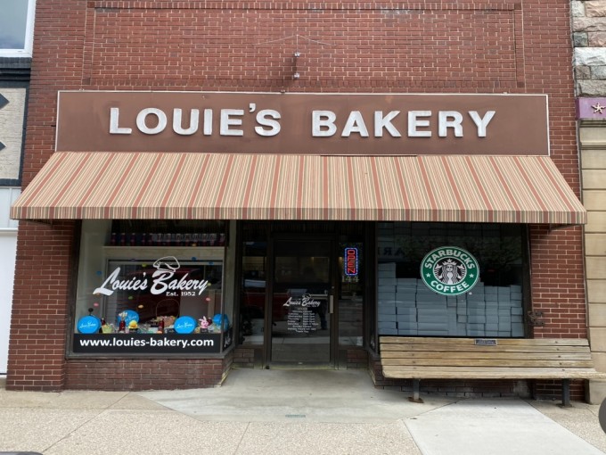 Louie's Bakery's iconic brick storefront with its cheerful striped awning stands as a beacon of sweetness in downtown Marshall, Michigan.