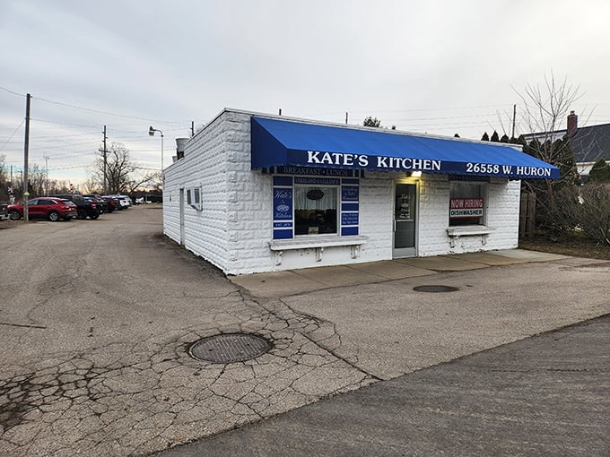 Kate's Kitchen exterior beckons with its humble white walls and royal blue awning &ndash; an unassuming treasure chest of culinary delights waiting to be discovered.