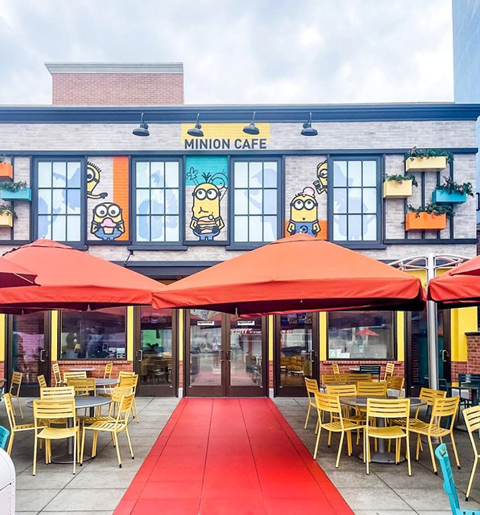 The Minion Cafe's vibrant exterior beckons with cheerful yellow characters and a welcoming red carpet &ndash; theme park dining with personality to spare!