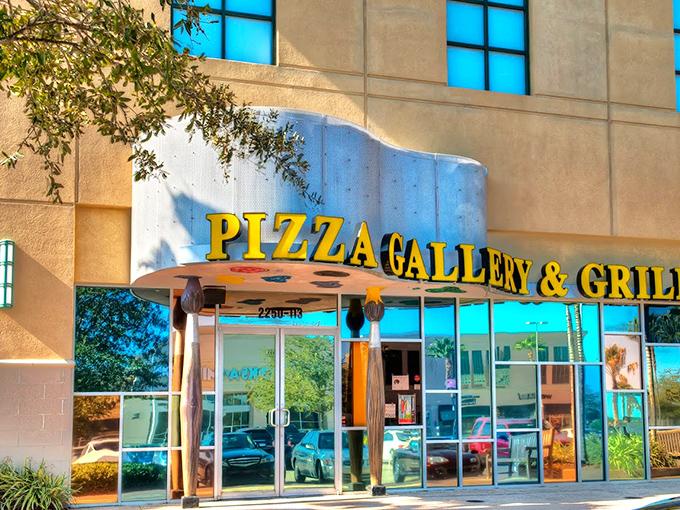 The gleaming yellow sign of Pizza Gallery & Grill beckons like a beacon of culinary creativity against the modern fa&ccedil;ade.