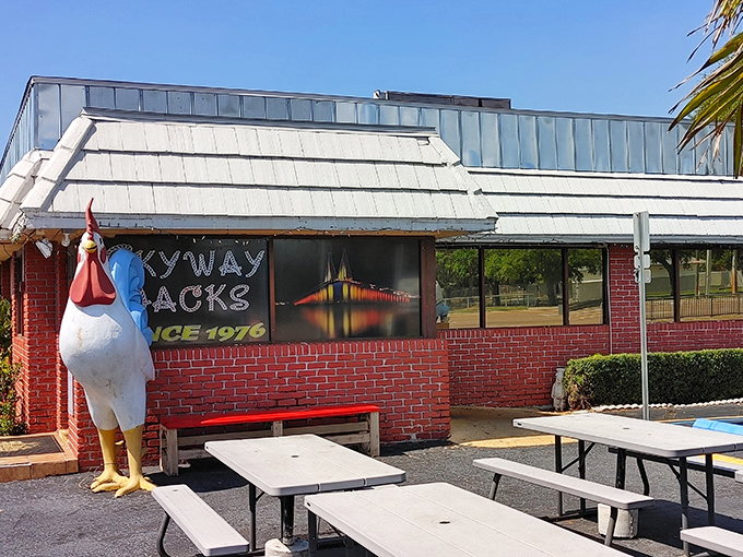 The iconic red brick exterior of Skyway Jack's, where that giant rooster statue practically dares you not to stop for breakfast.