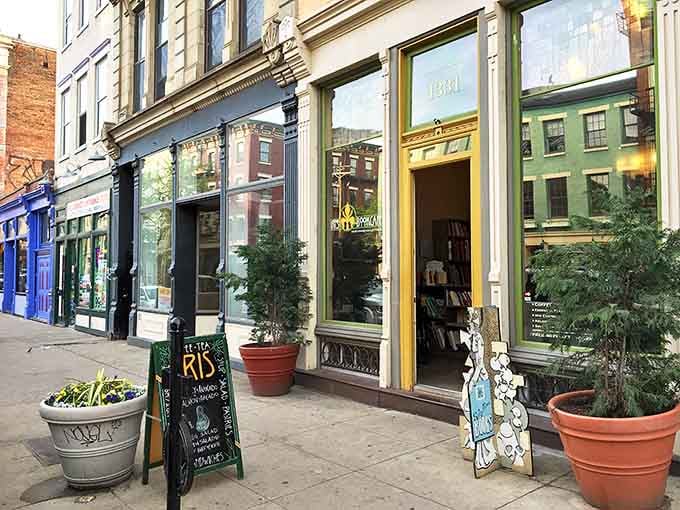 The inviting yellow door of Iris Book Cafe stands out on Main Street like a literary beacon, promising bookish delights within.