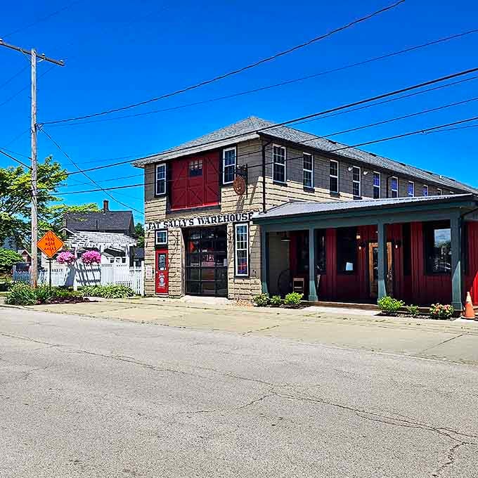 Stone meets wood at Fat Sally's exterior, where that iconic red barn door beckons treasure hunters like a vintage siren song.