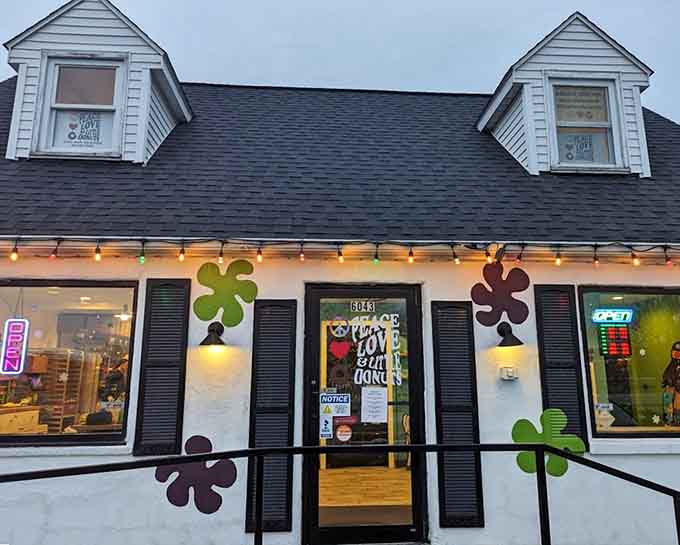 The psychedelic storefront beckons with colorful flower power decorations and a sunshine-yellow sign that promises three essentials for happiness: peace, love, and donuts.