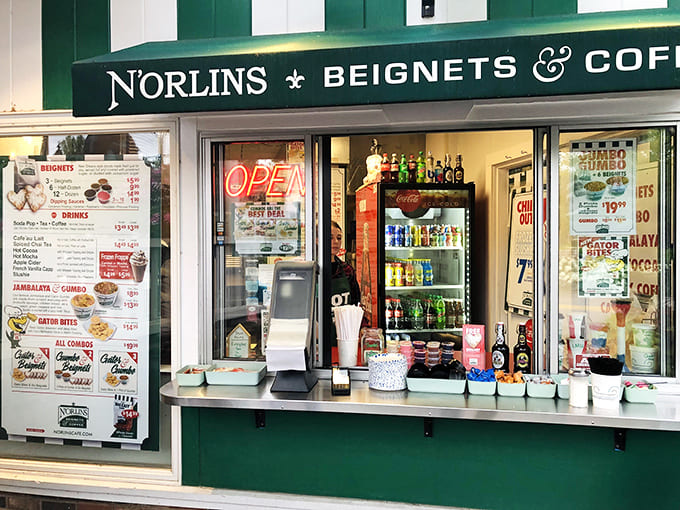 That green and white storefront is your gateway to Louisiana flavors, beckoning you inside with promises of powdered sugar and Cajun spice.