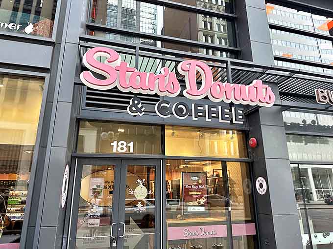 The iconic pink Stan's Donuts sign glows like a beacon of sugary hope on Michigan Avenue, promising sweet salvation to weary Chicago travelers.