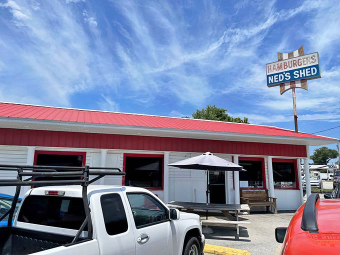 Ned's Shed stands proudly against the Illinois sky, its vintage sign promising hamburger heaven to weary travelers seeking authentic roadside bliss.