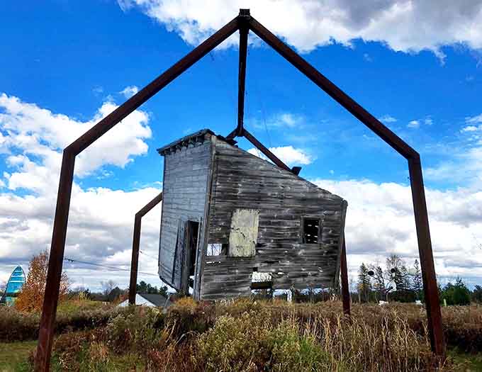A weathered wooden house suspended in a metal frame &ndash; Franconia's way of saying "home is where you hang your entire building."