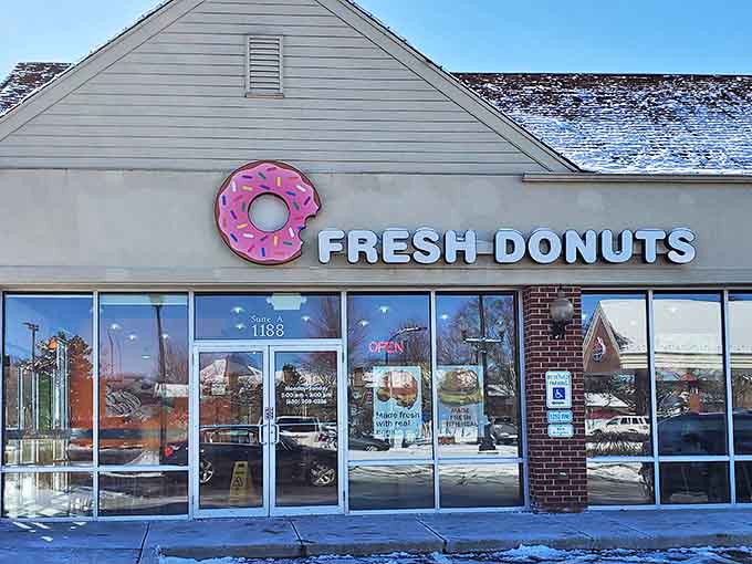 The iconic pink donut sign beckons breakfast enthusiasts to this unassuming Geneva storefront, promising sweet salvation from ordinary morning meals.