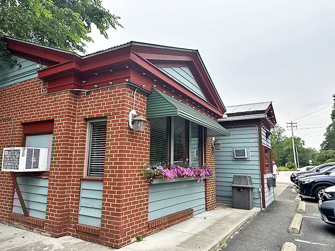 The charming brick and teal exterior of Gasoline Alley welcomes visitors with its retro service station vibe and colorful flower boxes.