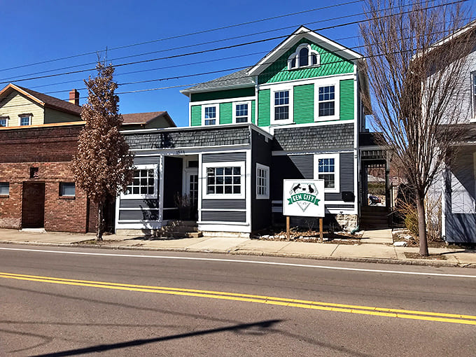 The distinctive green and gray exterior of Gem City Catfe stands out on the street like a friendly beacon for coffee and cat enthusiasts alike.